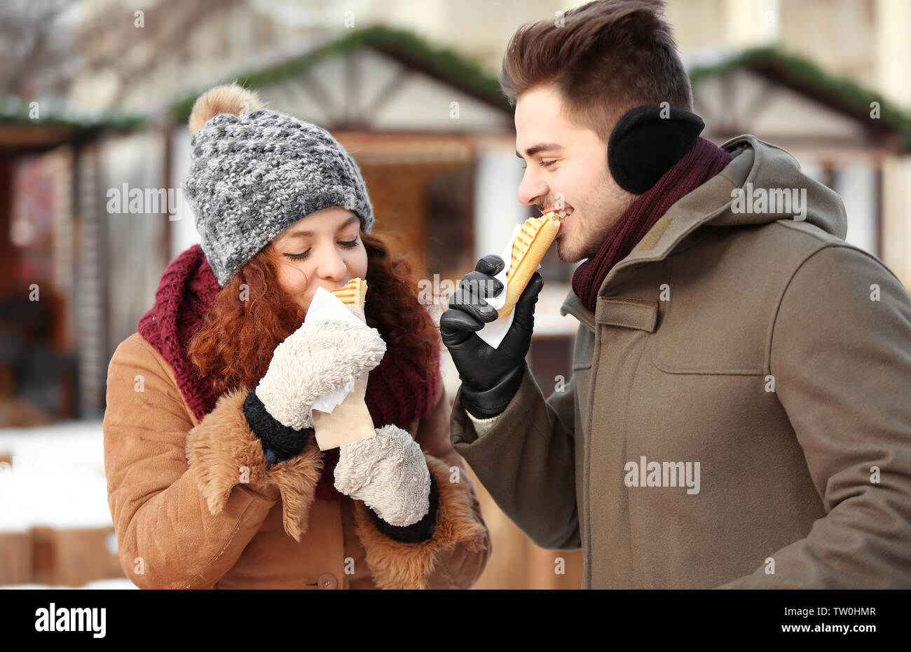 Cute couple having lunch break on winter market Stock Photo - Alamy