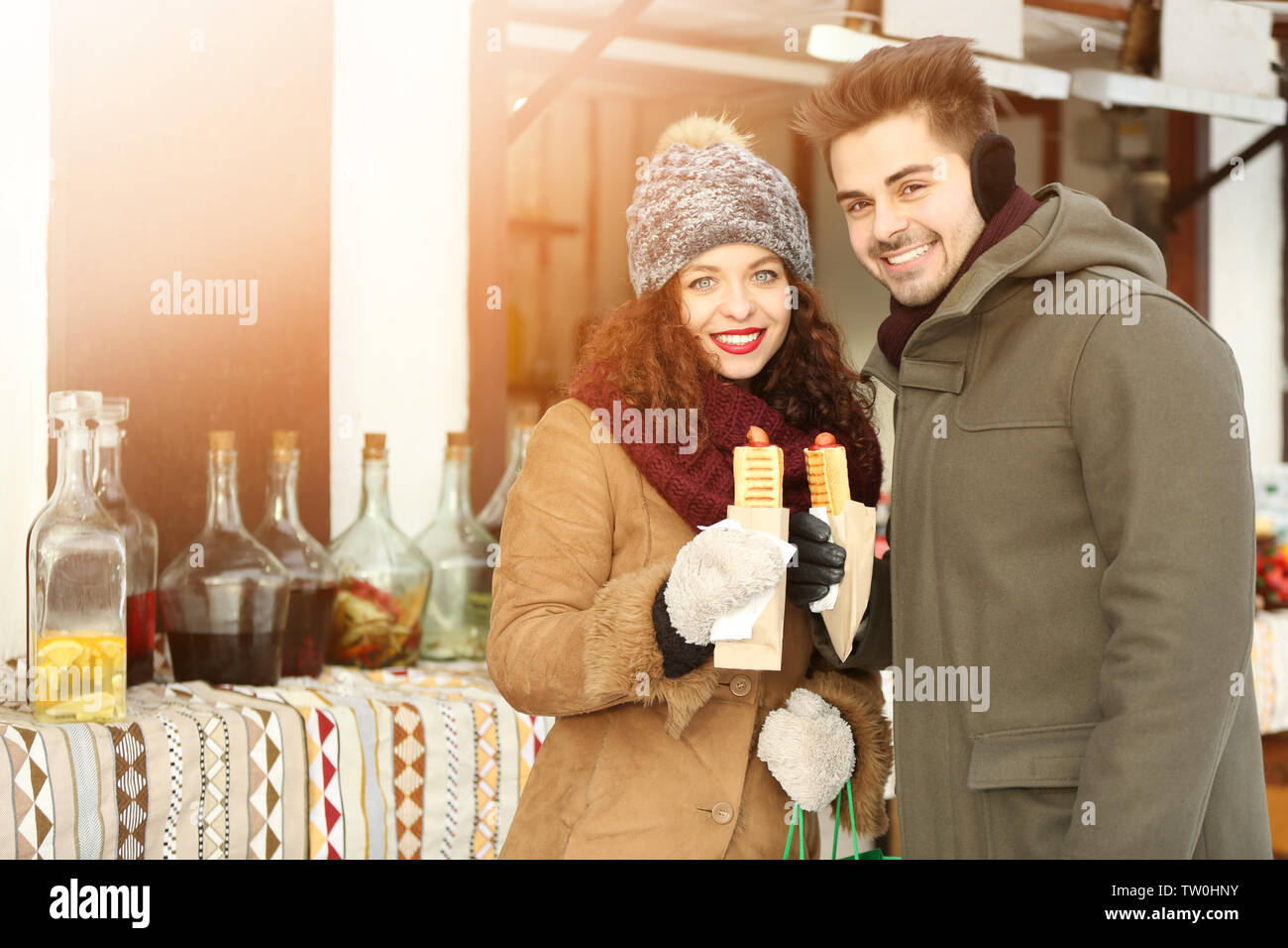 Cute couple having lunch break on winter market Stock Photo - Alamy
