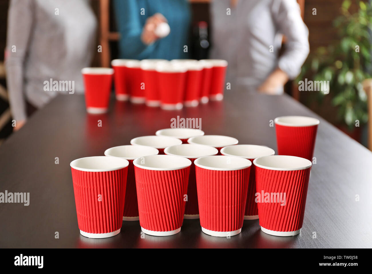 People playing Beer Pong on table at bar Stock Photo - Alamy