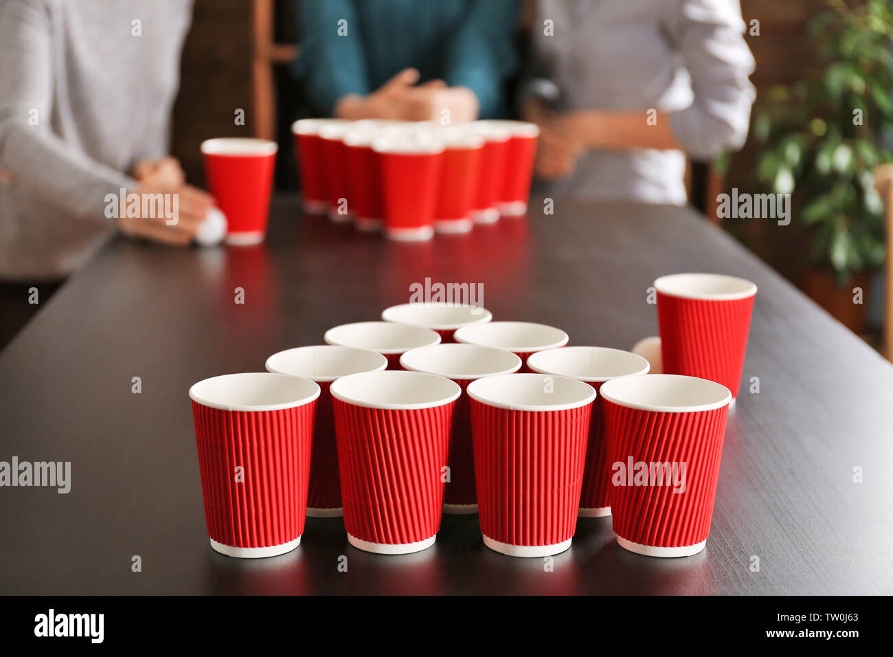 People playing Beer Pong on table at bar Stock Photo - Alamy