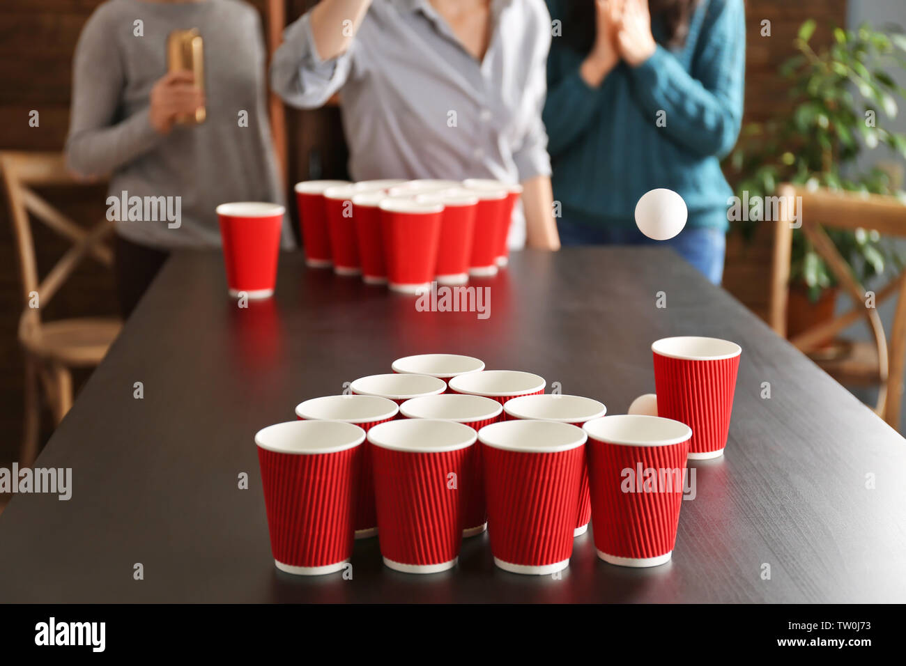People playing Beer Pong on table at bar Stock Photo - Alamy