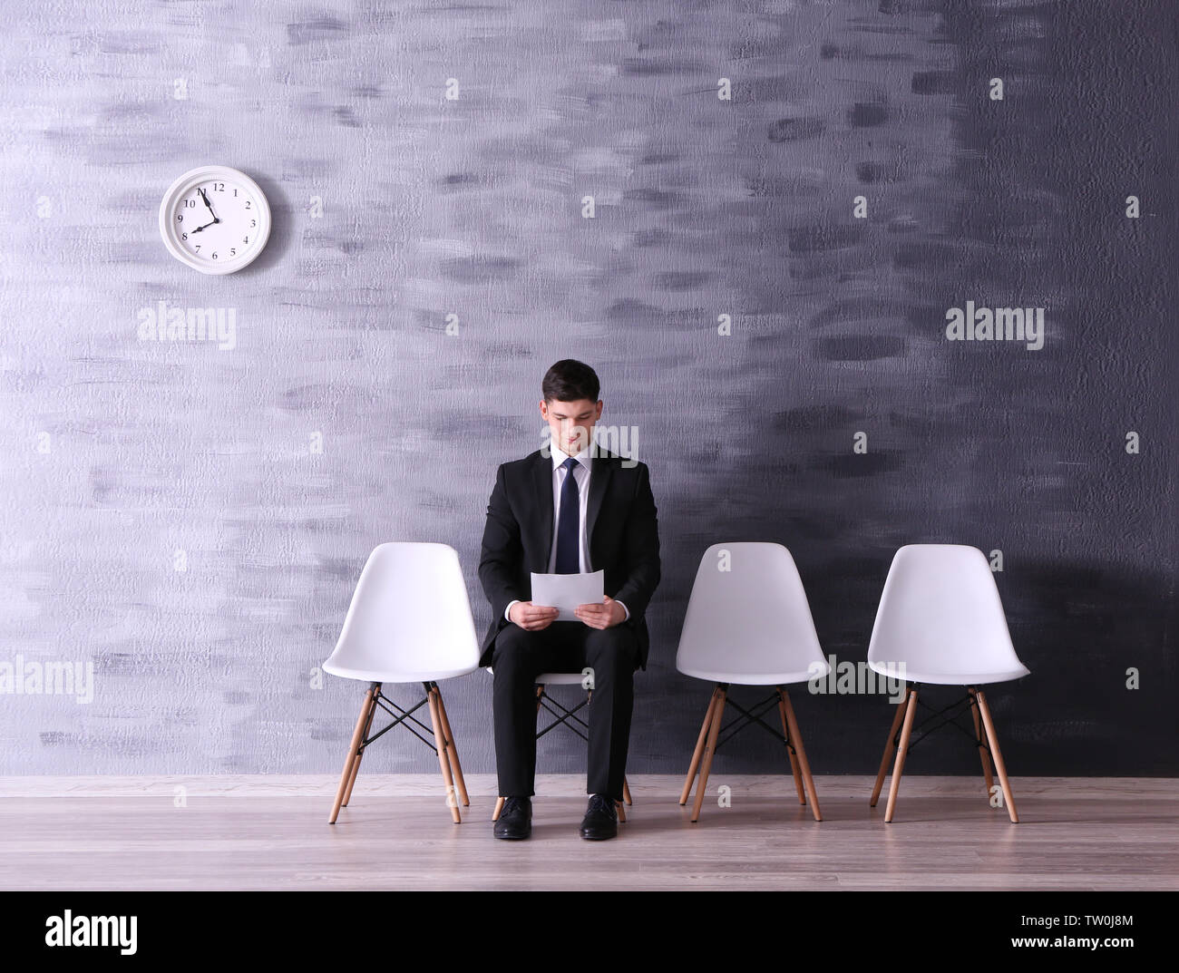 Young man waiting for job interview in reception hall Stock Photo - Alamy