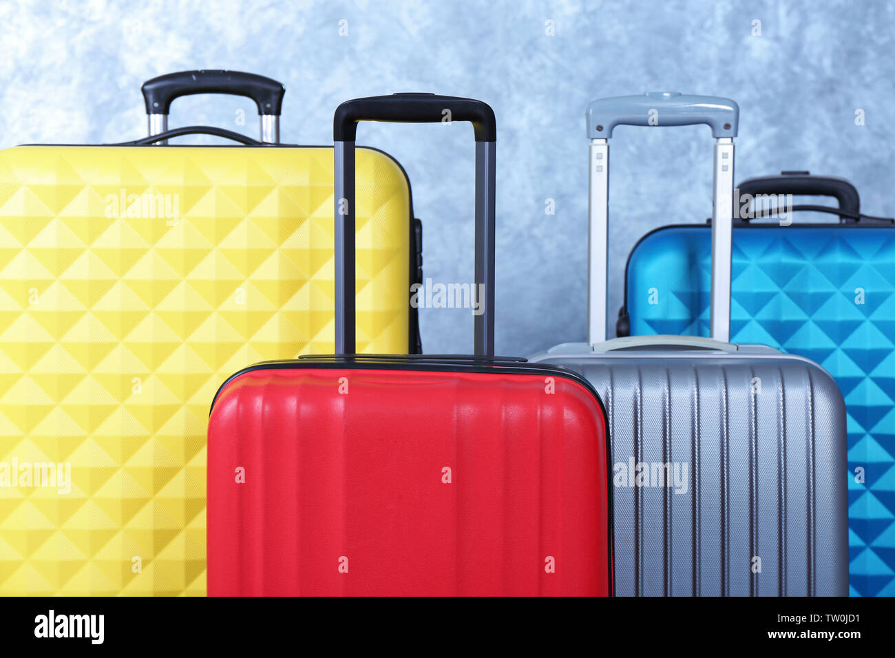 Color suitcases on light background Stock Photo - Alamy