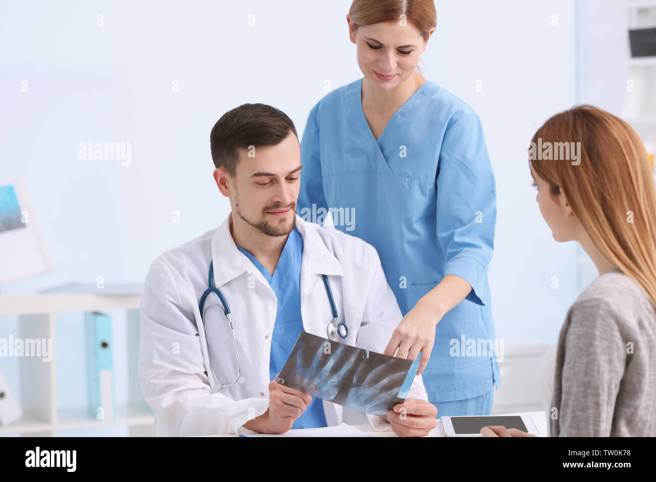 Doctor showing x-ray photo to patient in clinic Stock Photo - Alamy