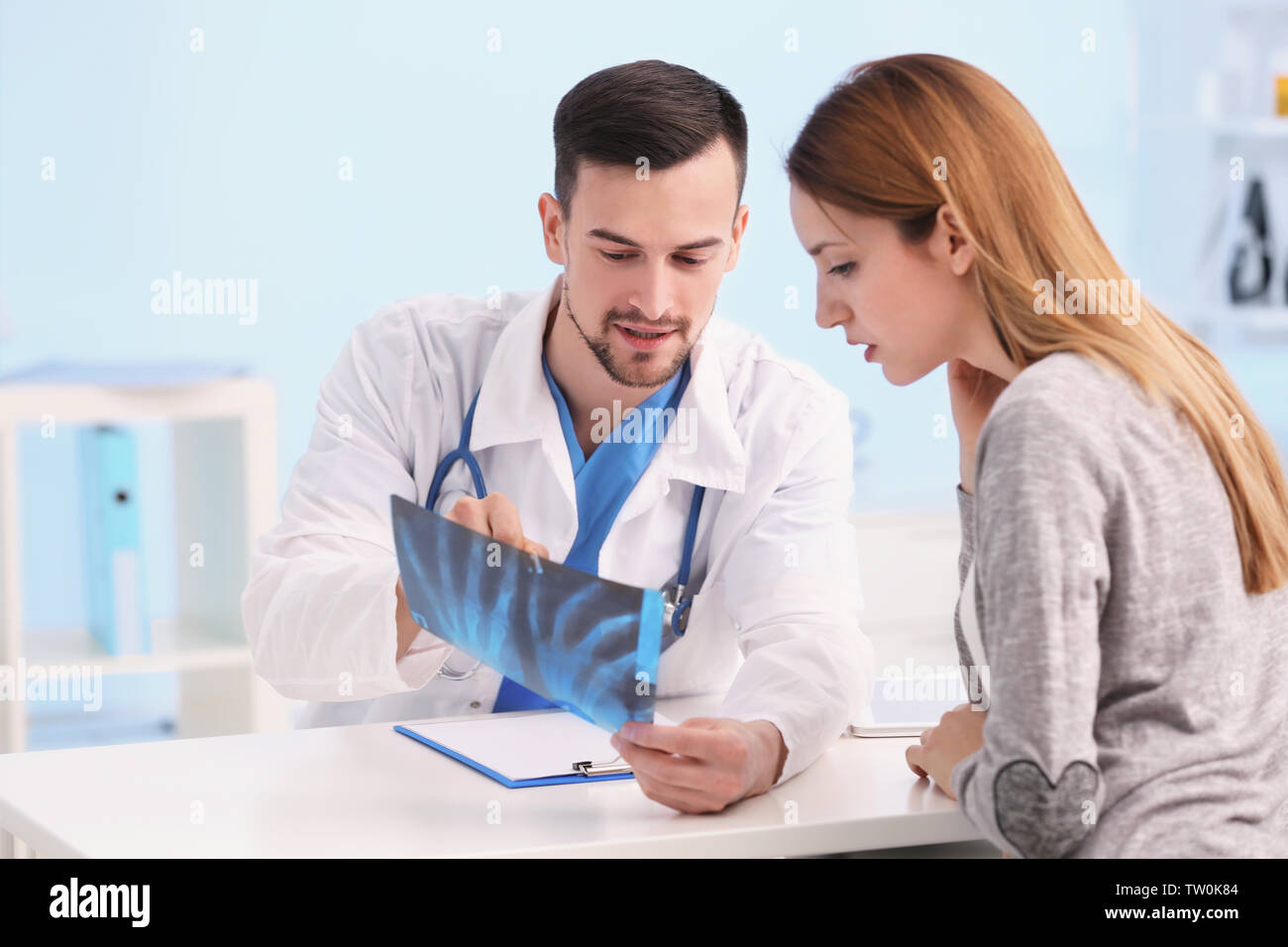 Doctor showing x-ray photo to patient in clinic Stock Photo - Alamy
