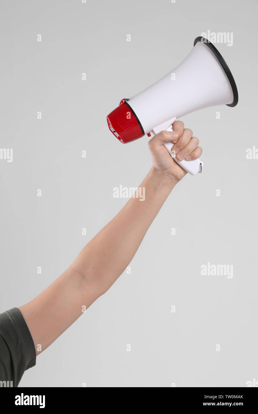 Male hand holding megaphone on light background Stock Photo - Alamy