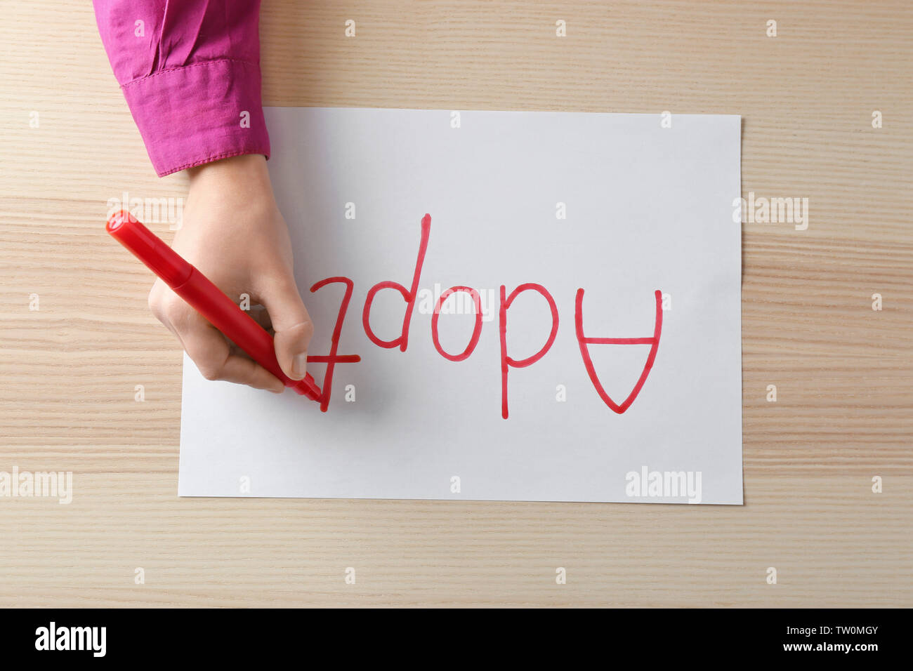 Female hand writing word "Adoption Stock Photo - Alamy