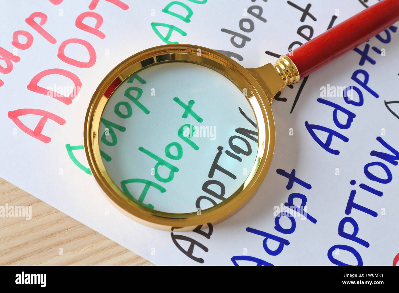 Magnifier and paper with words "Adoption", closeup Stock Photo - Alamy