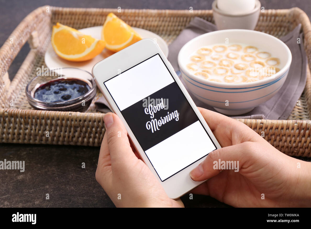 Female hands holding cellphone with sign GOOD MORNING while having ...