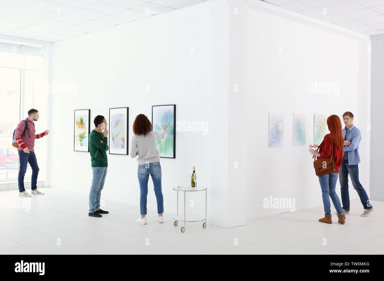 Young people in modern art gallery hall Stock Photo - Alamy