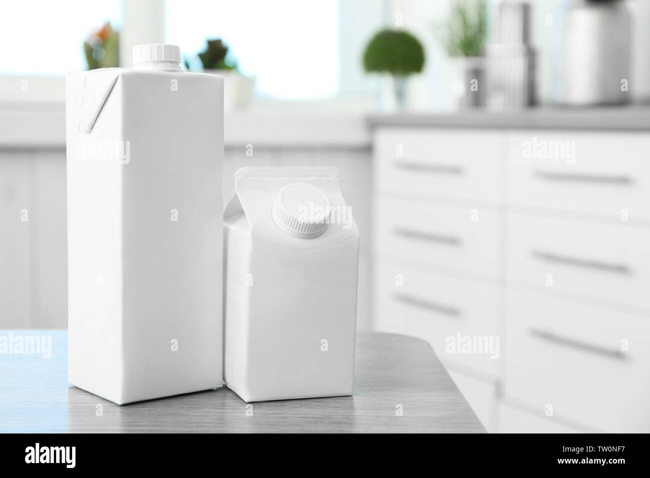 Two simple milk boxes on table in kitchen Stock Photo - Alamy