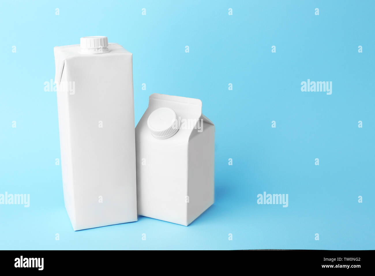 Two simple milk boxes on color background Stock Photo - Alamy