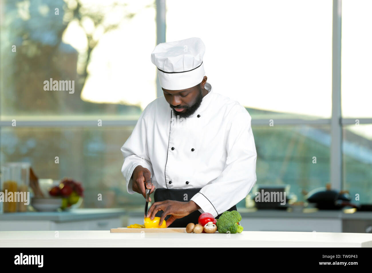 African American chef cutting vegetables in kitchen Stock Photo - Alamy