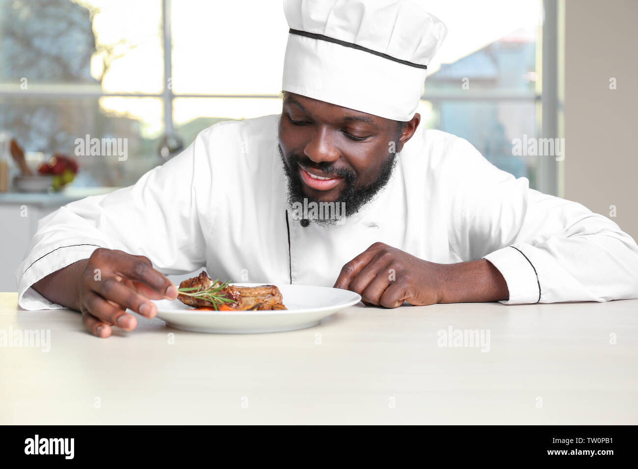 African American chef cooking tasty meat in kitchen Stock Photo - Alamy