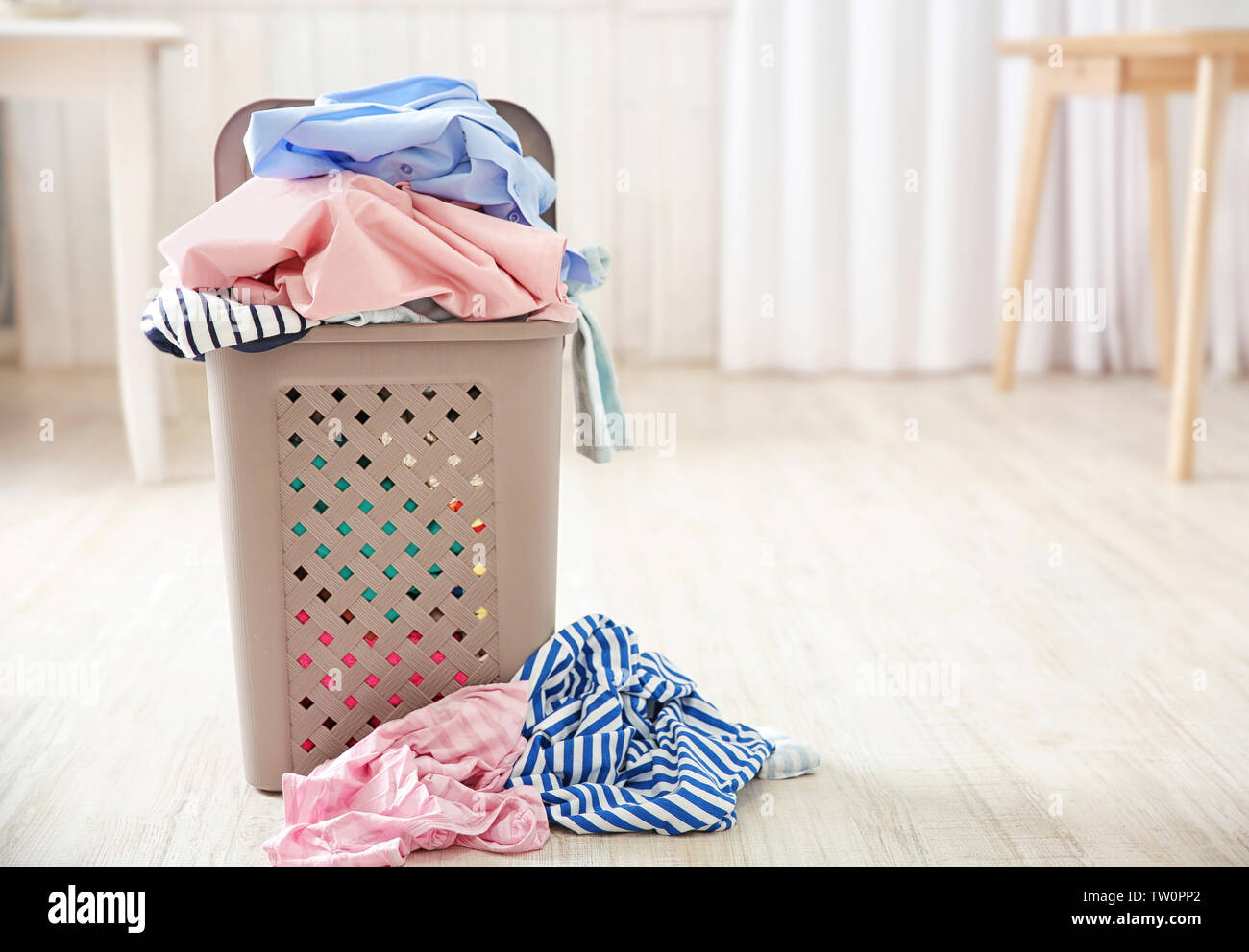 Pile of clothes in plastic laundry basket indoors Stock Photo - Alamy