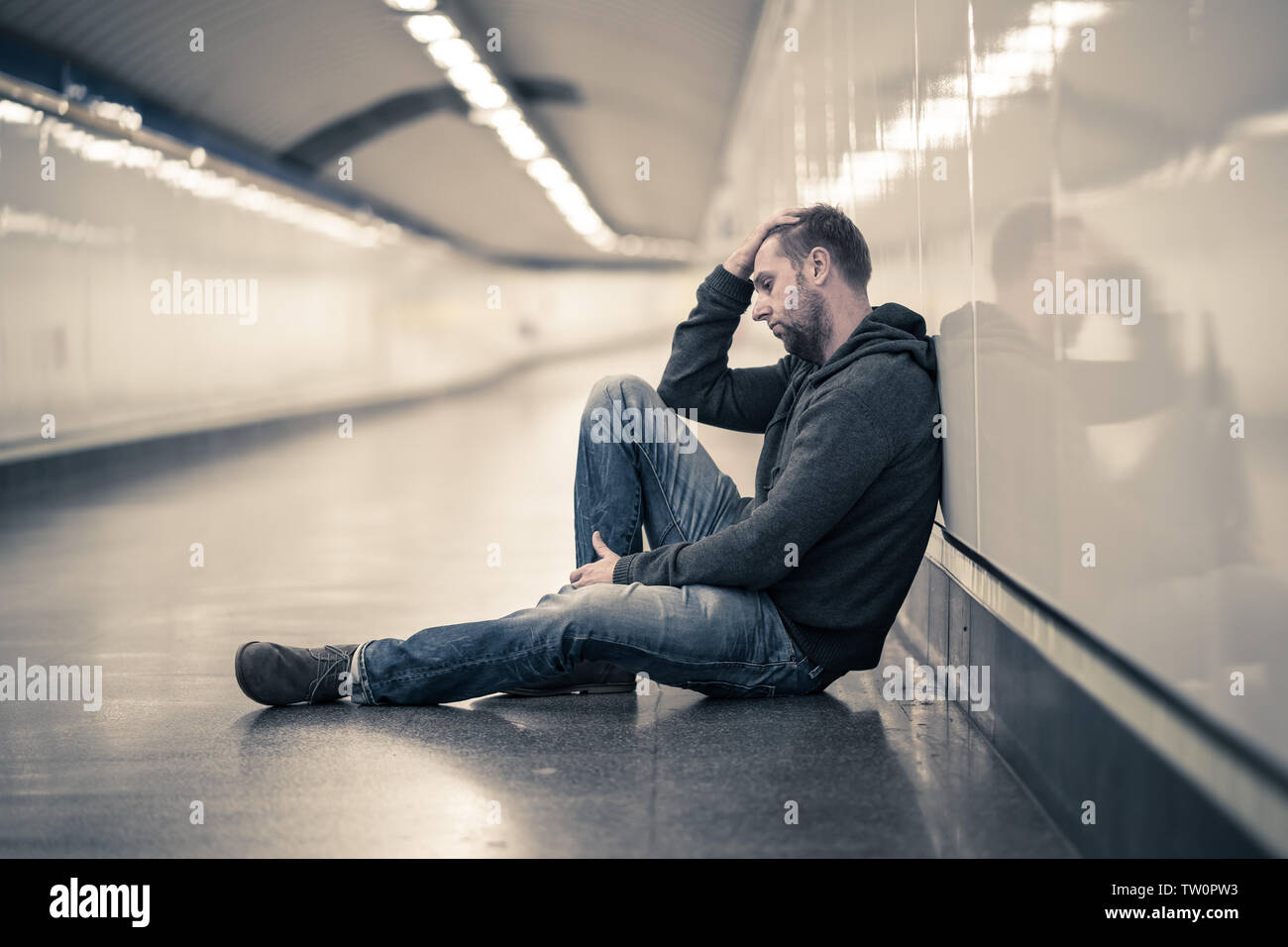 Sad young man crying suffering depression stress sitting on ground ...