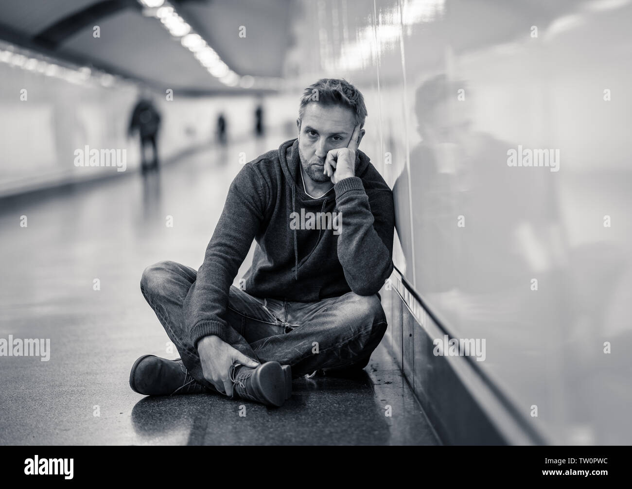 Sad young man crying suffering depression stress sitting on ground ...
