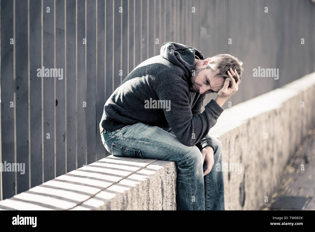 Young attractive man suffering from depression stress sitting alone and ...