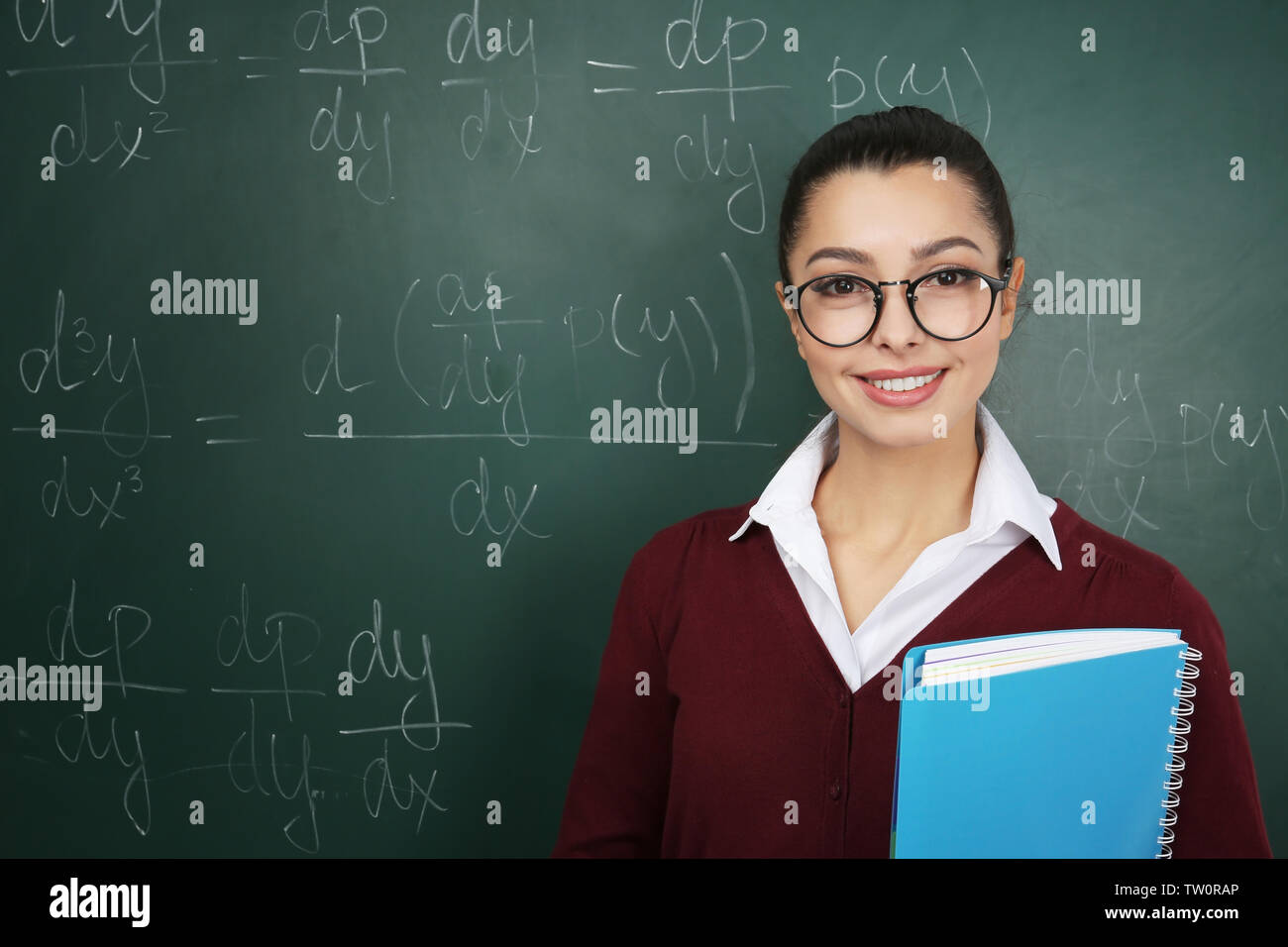 Beautiful young teacher near blackboard in classroom Stock Photo - Alamy