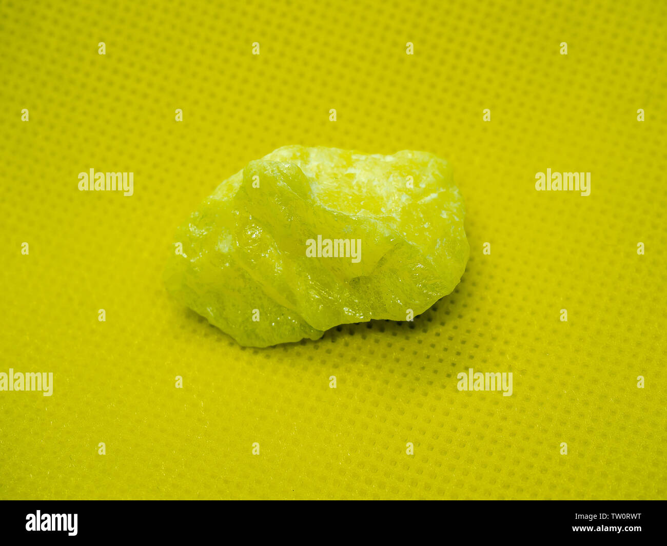 Geological specimen of natural mineral sulfur, on yellow background ...