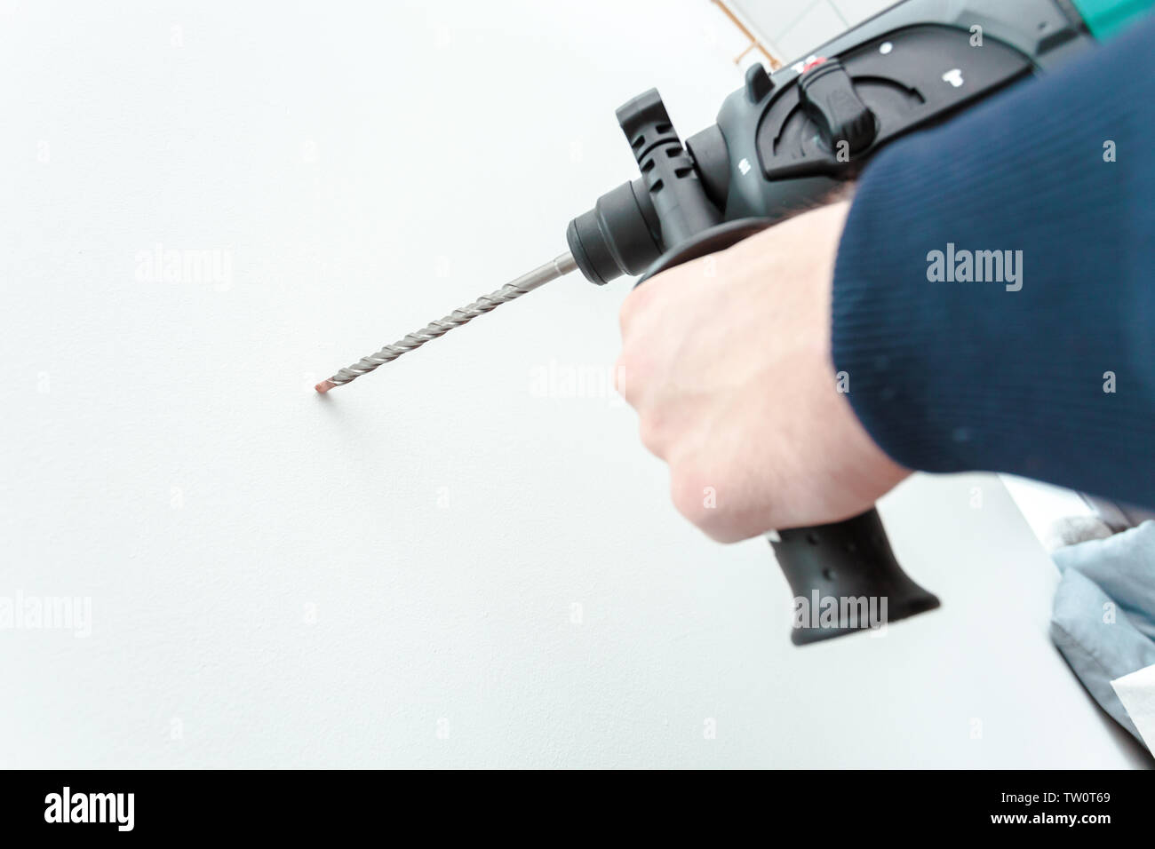 Use hammer drill to drill the wall Stock Photo - Alamy