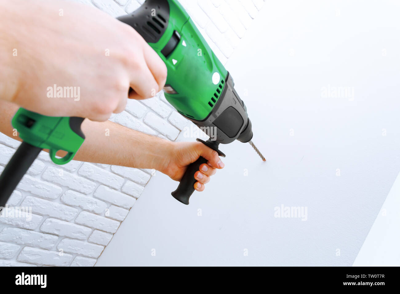 Use hammer drill to drill the wall Stock Photo - Alamy