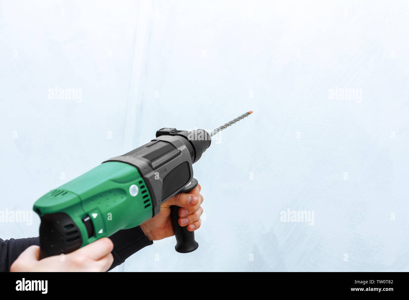 Use hammer drill to drill the wall Stock Photo - Alamy