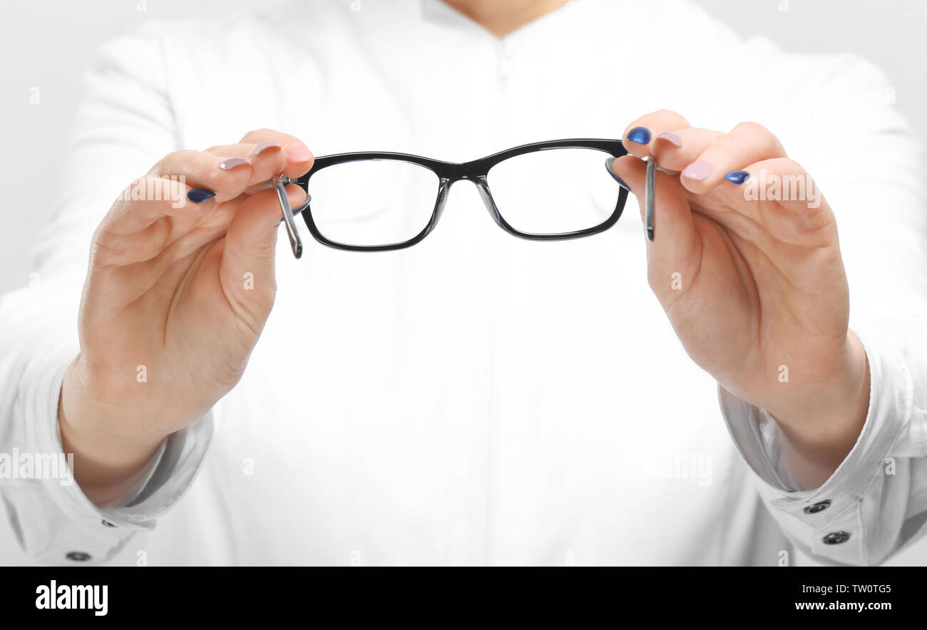 Mature female ophthalmologist with glasses on white background, closeup ...