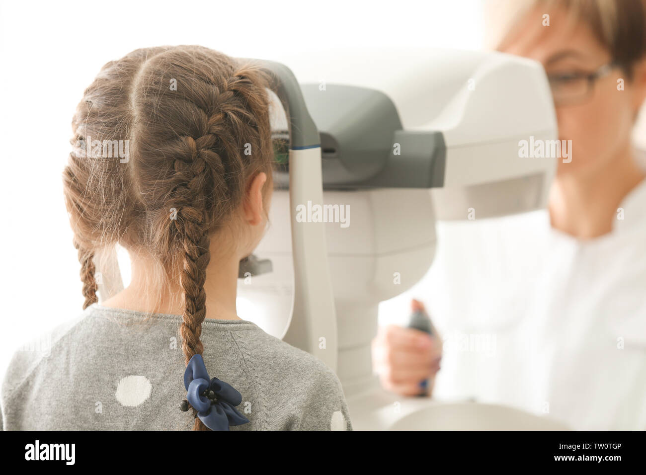 Ophthalmologist measuring intraocular pressure of little girl in clinic ...