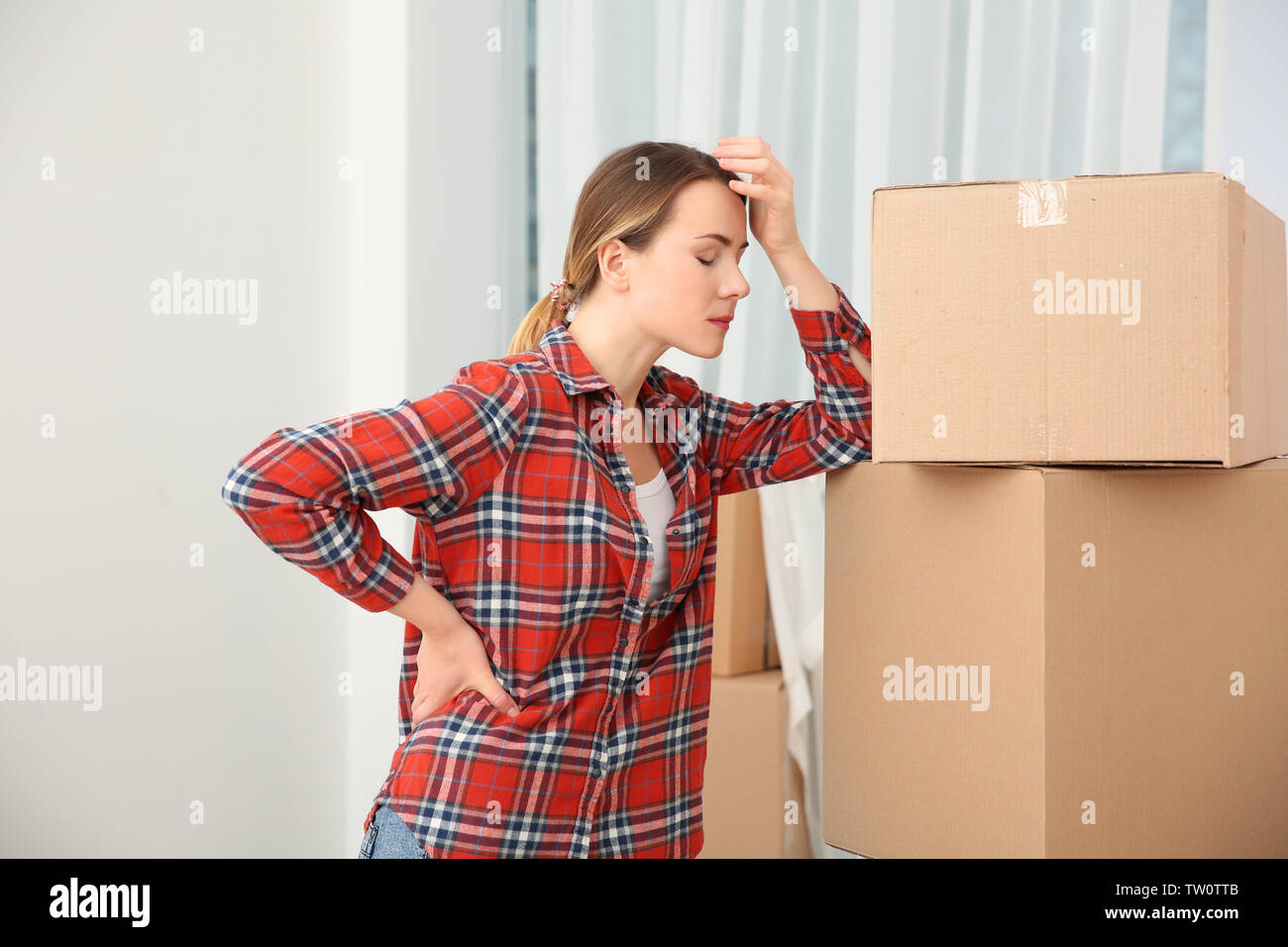 Young woman suffering from pain after moving heavy box Stock Photo - Alamy