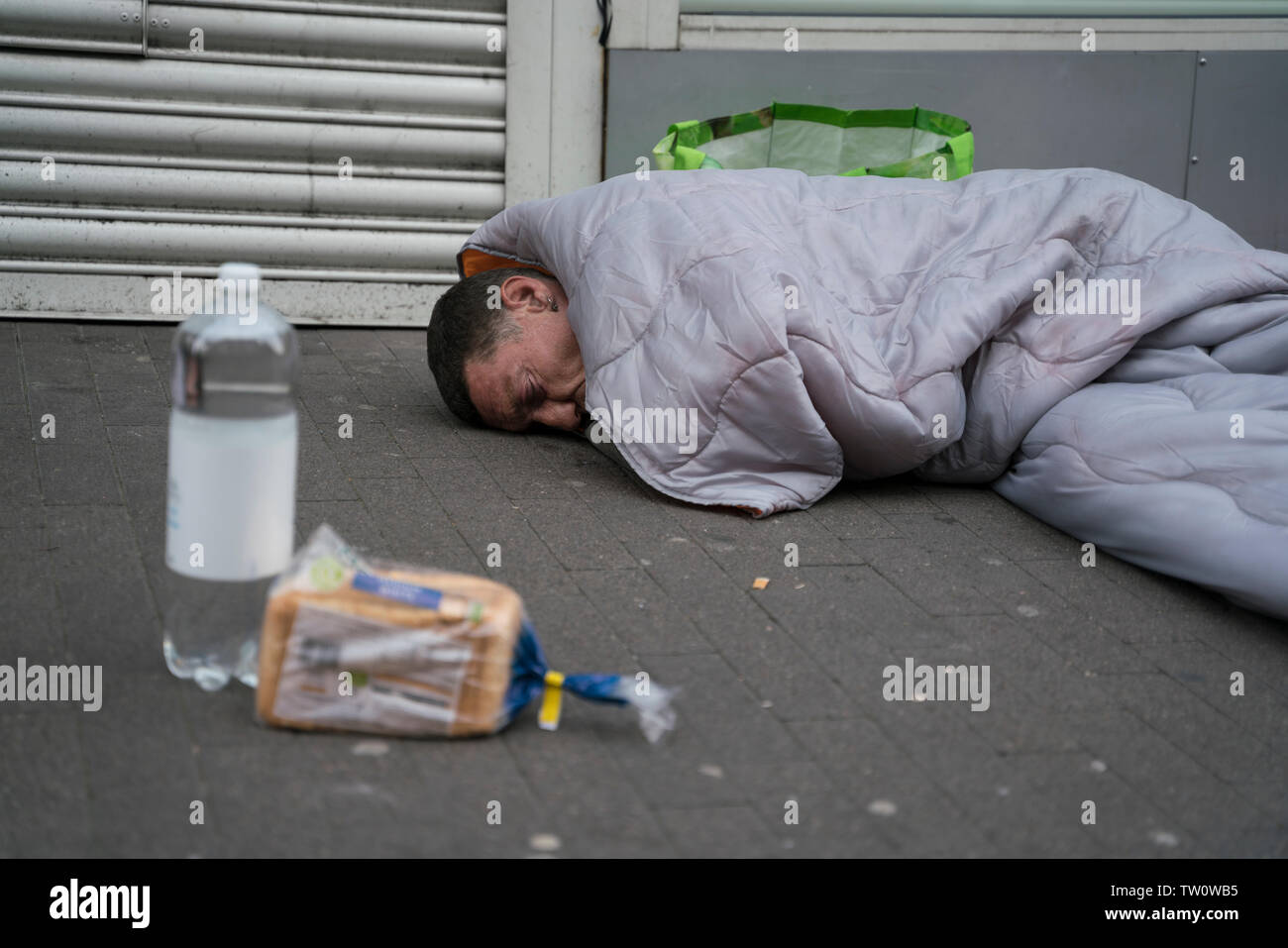 Homeless man with bread and water Stock Photo - Alamy