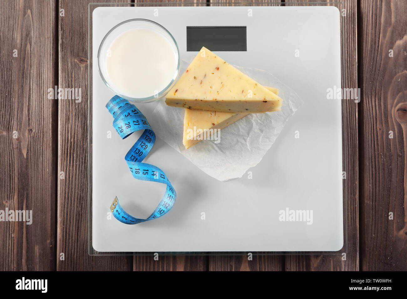 Kitchen scales with different dairy products on wooden background Stock ...