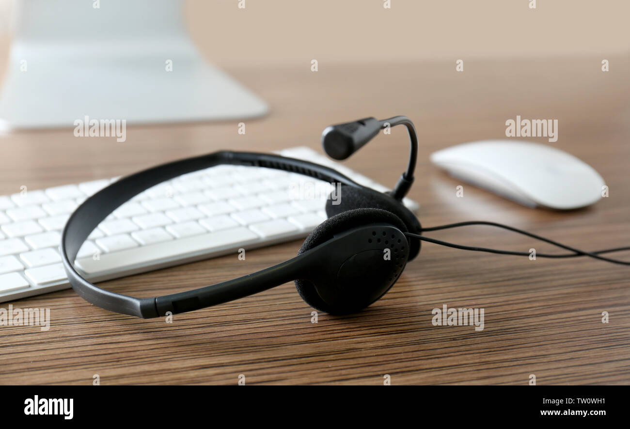 Modern headphones and wireless computer devices on wooden table Stock ...