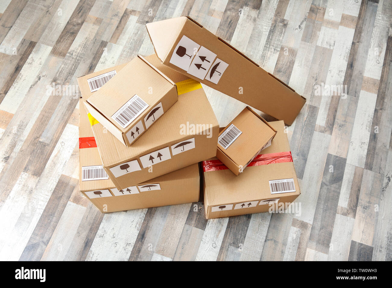 Cardboard boxes on wooden floor Stock Photo - Alamy