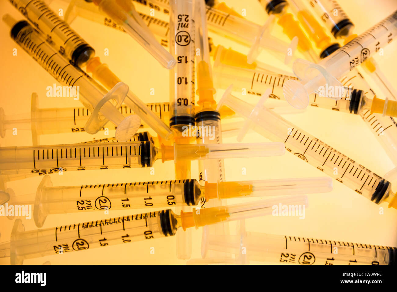 Group of syringes on orange background Stock Photo - Alamy