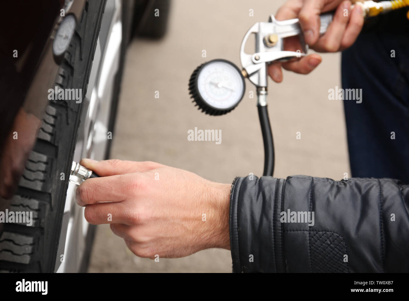Auto mechanic checking tire pressure, closeup Stock Photo - Alamy