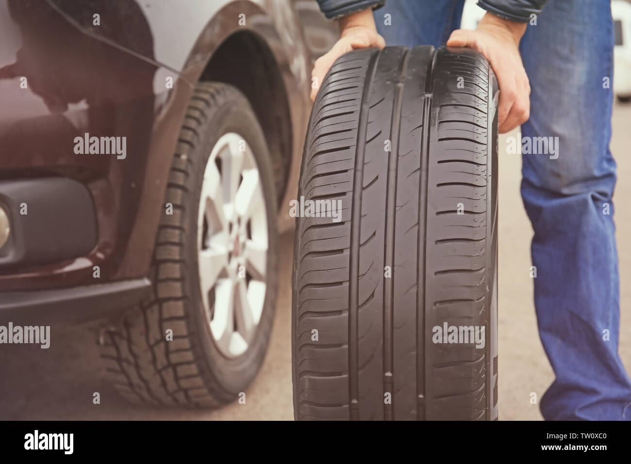 Closeup view of man pushing tire outdoors Stock Photo - Alamy