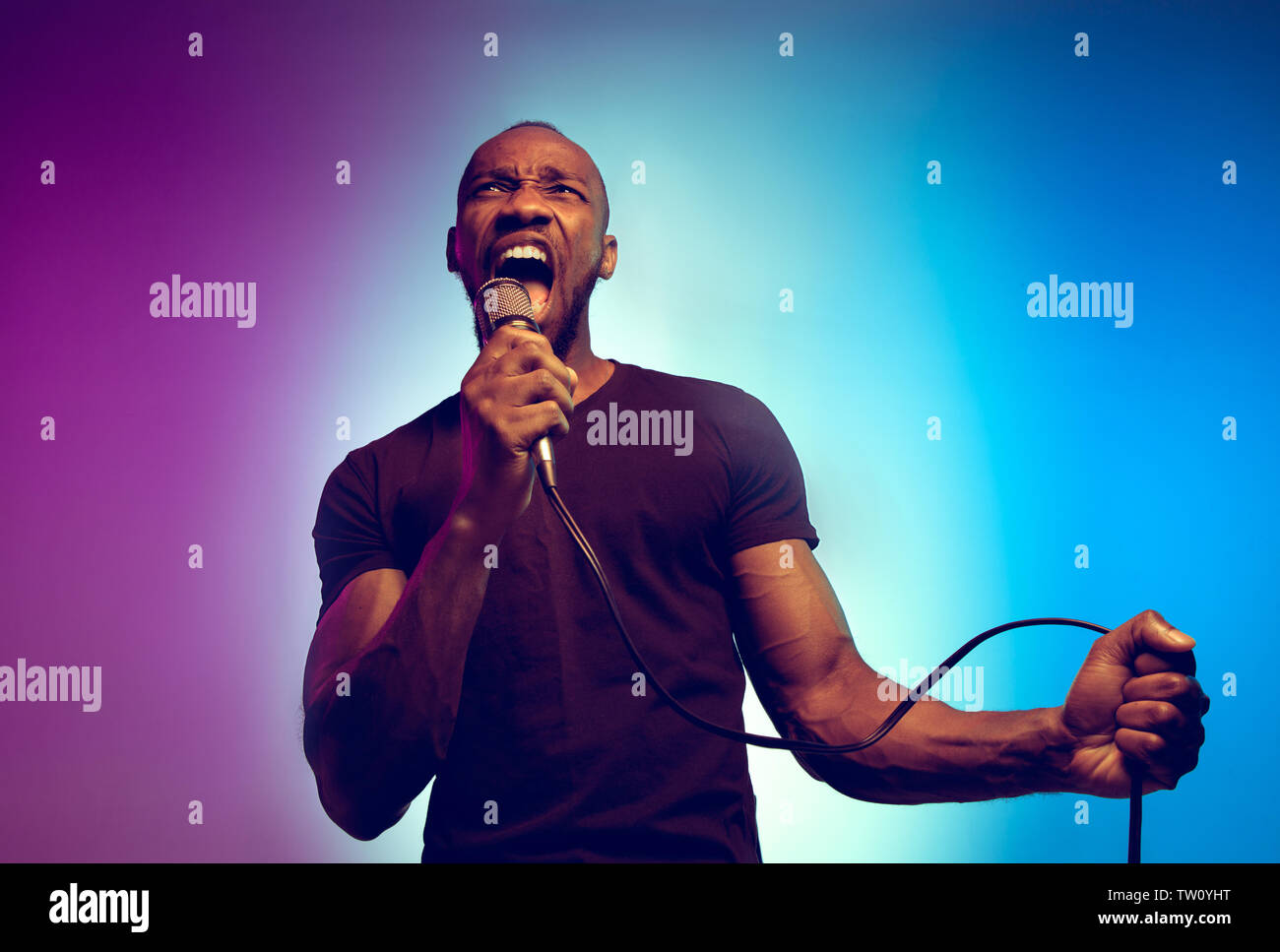 Young african-american jazz musician singing a song on gradient purple ...