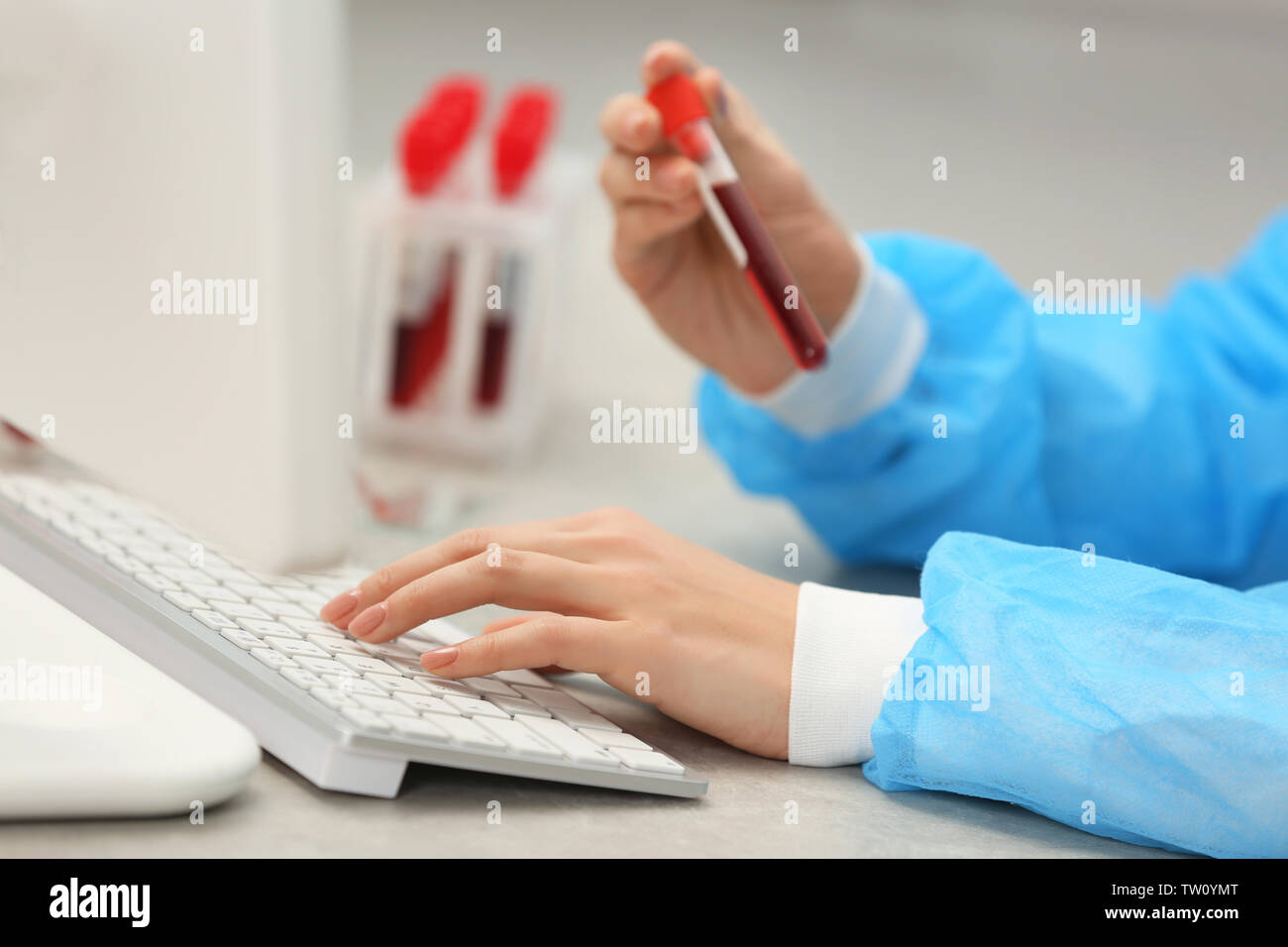 Scientist entering data of blood sample in computer at laboratory Stock ...