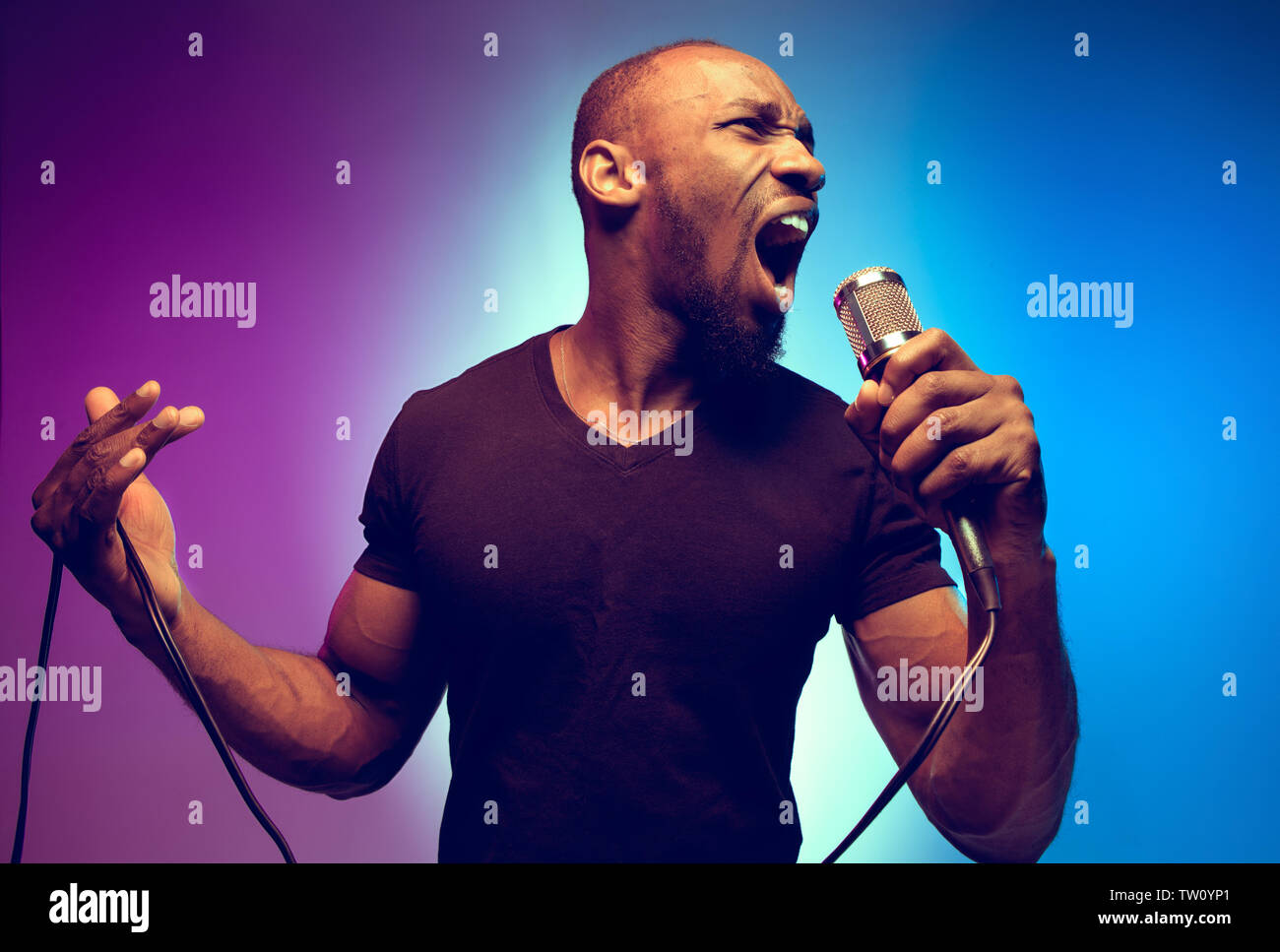 Young african-american jazz musician singing a song on gradient purple ...