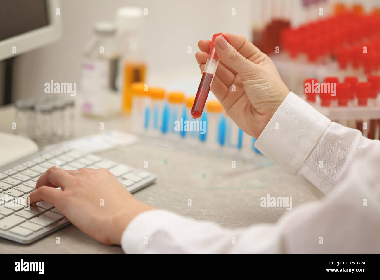 Scientist entering data of blood sample in computer at laboratory Stock ...