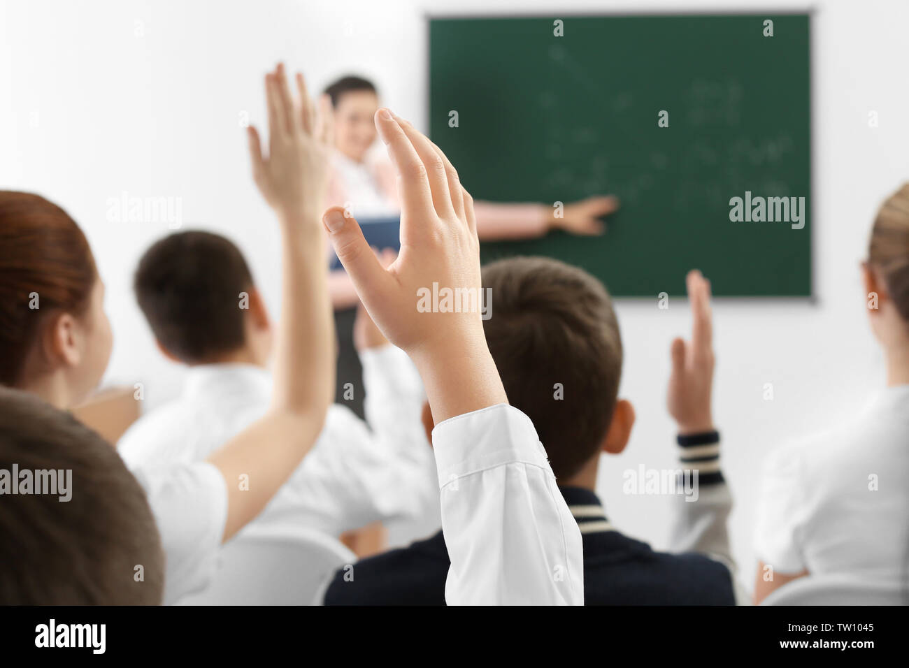 Schoolchildren raising hands for answer during lesson Stock Photo - Alamy Schoolchildren raising hands for answer during lesson Stock Photo - Alamy