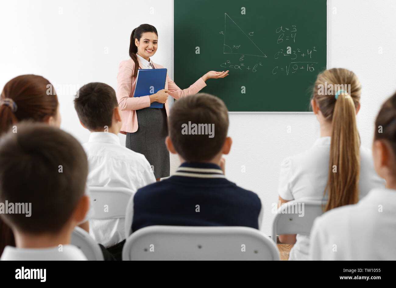 Female teacher conducting lesson in classroom Stock Photo - Alamy