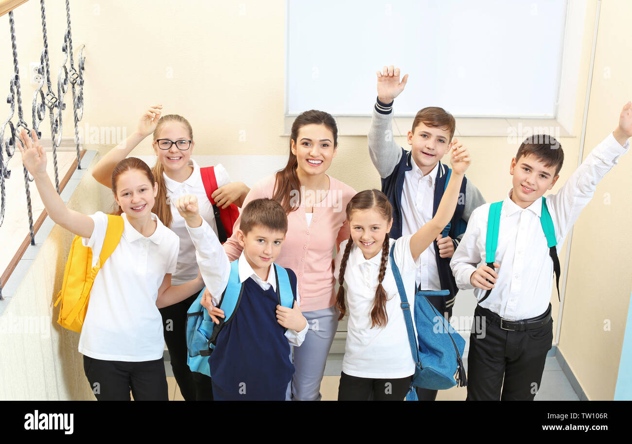Teacher with children in school corridor during class break Stock Photo ...