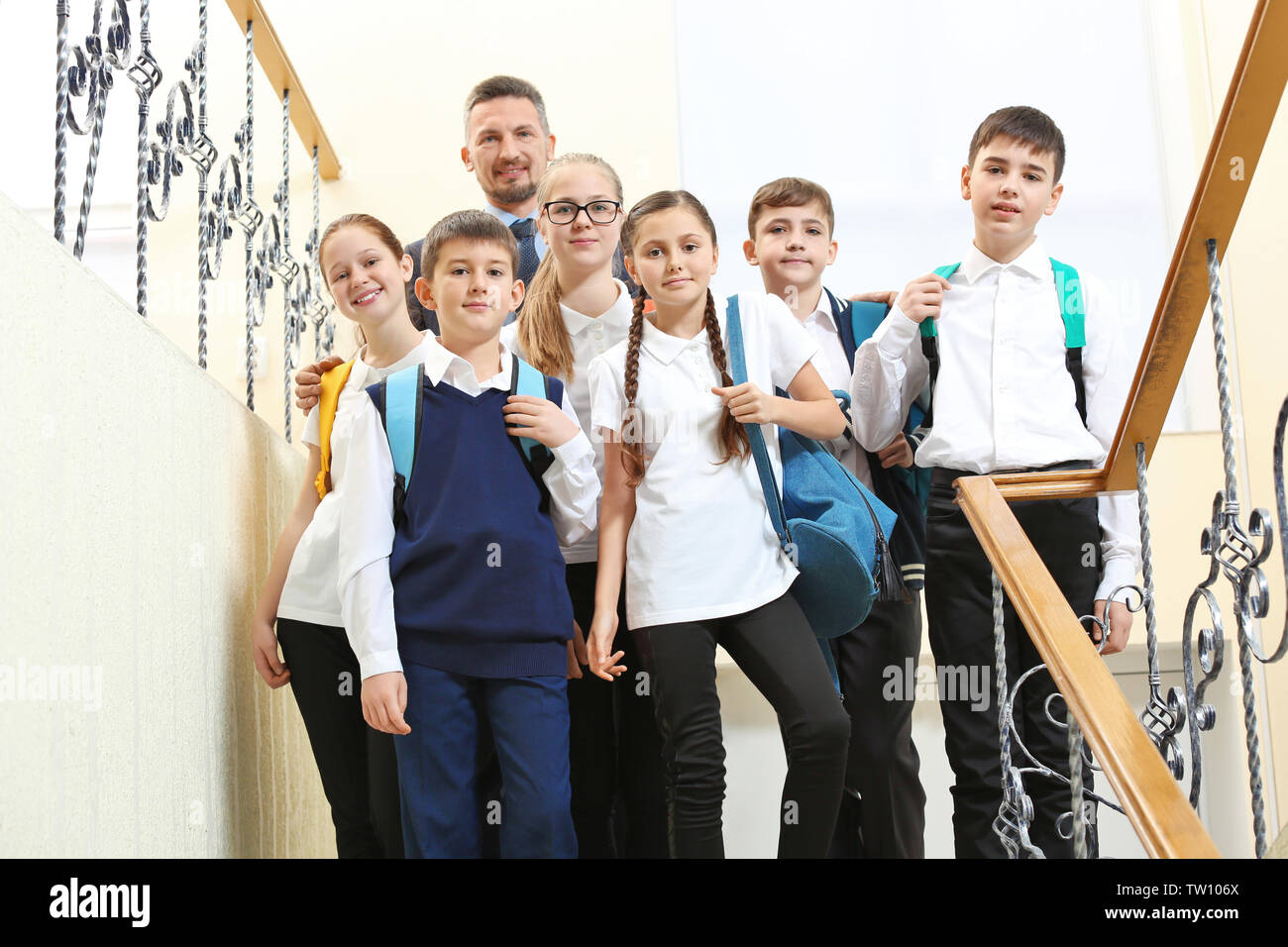 Teacher with children in school corridor during class break Stock Photo ...