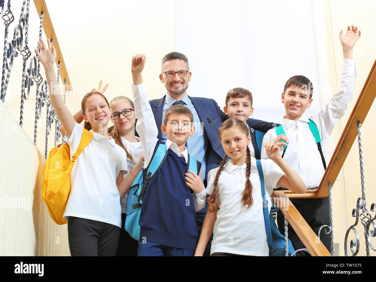 Teacher with children in school corridor during class break Stock Photo ...