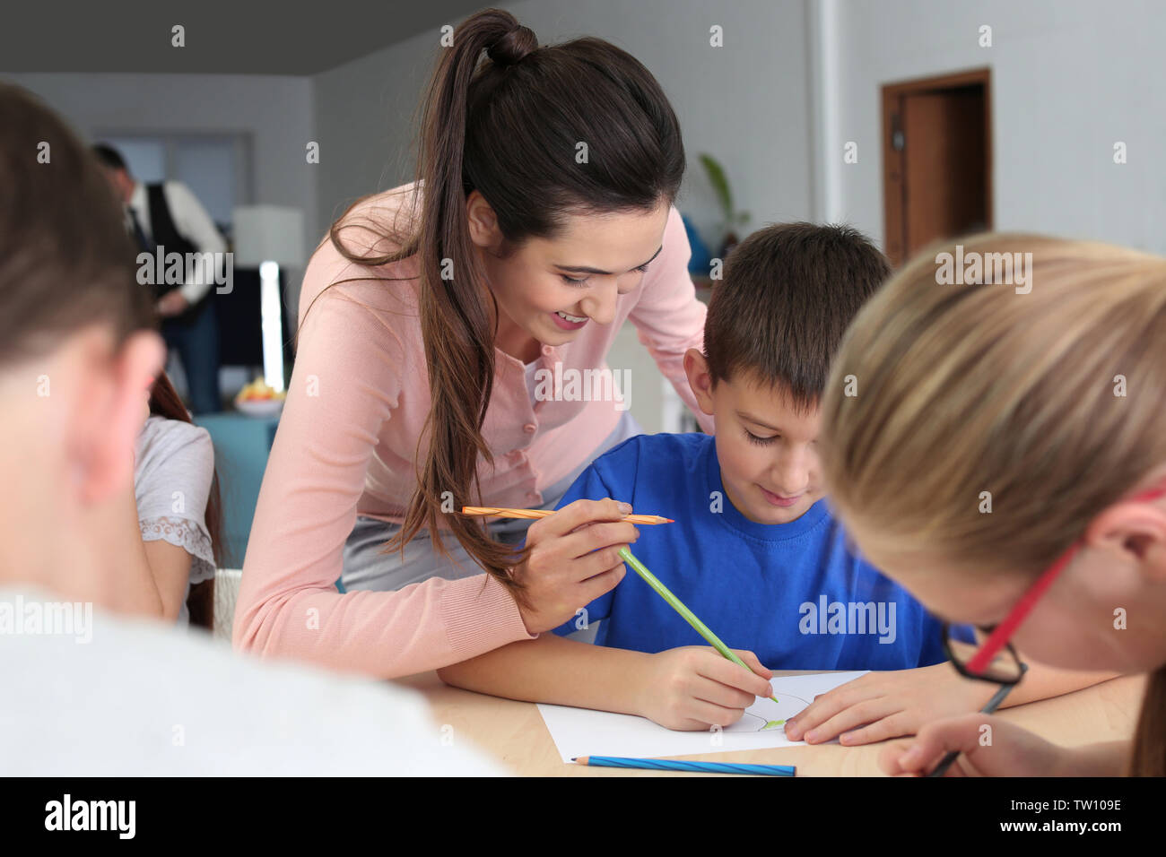 Female teacher conducting lesson in classroom Stock Photo - Alamy