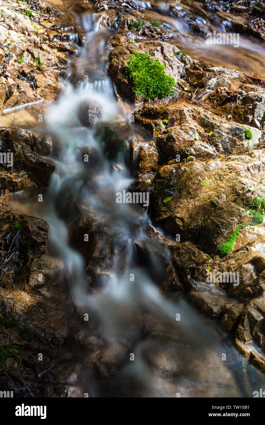 Creek flowing rocks Stock Photo - Alamy