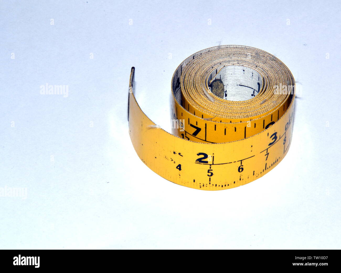 A studio shot of an old fashioned tape measure, taken on a white ...