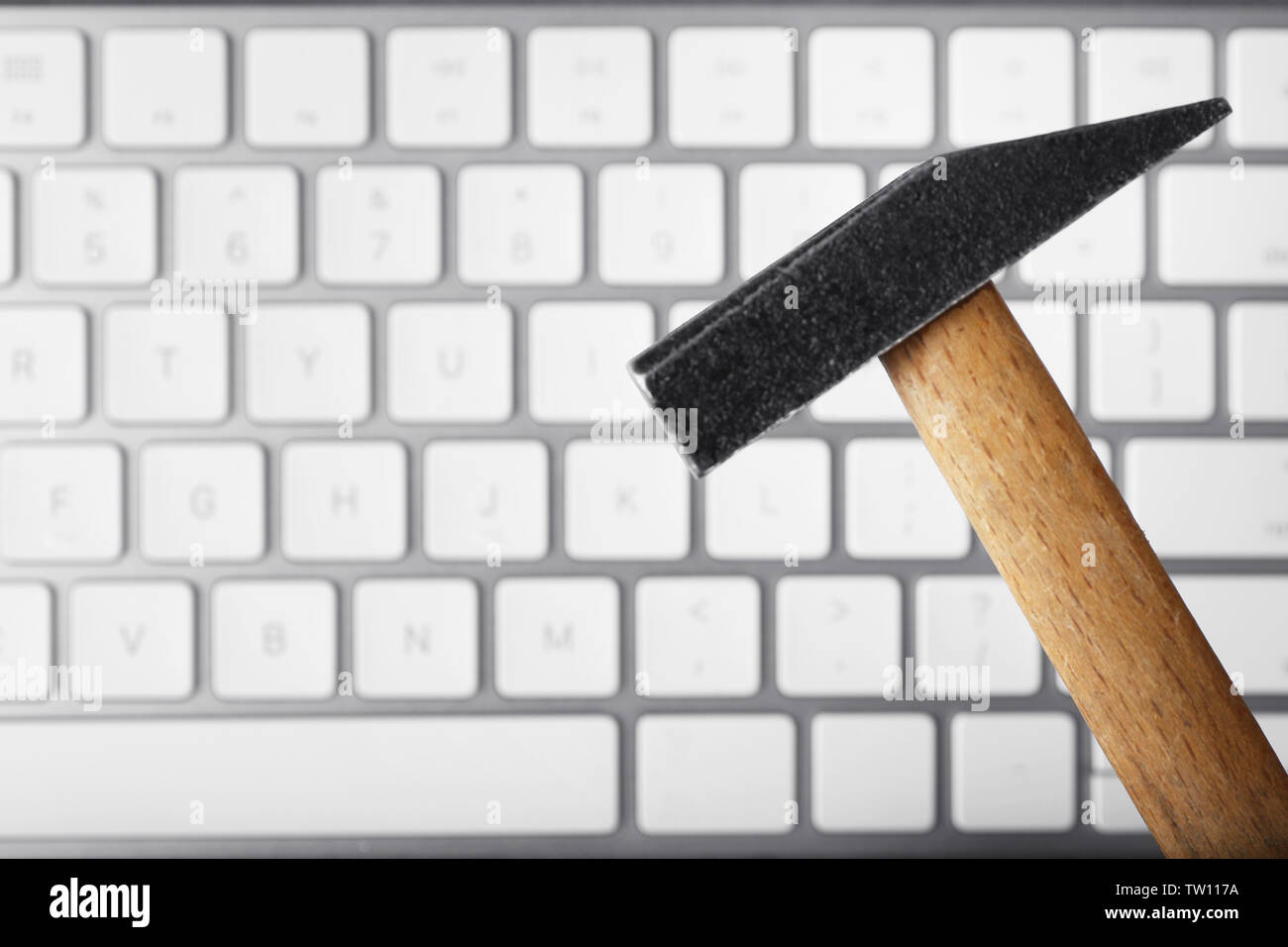 Hammer on computer keyboard background Stock Photo - Alamy